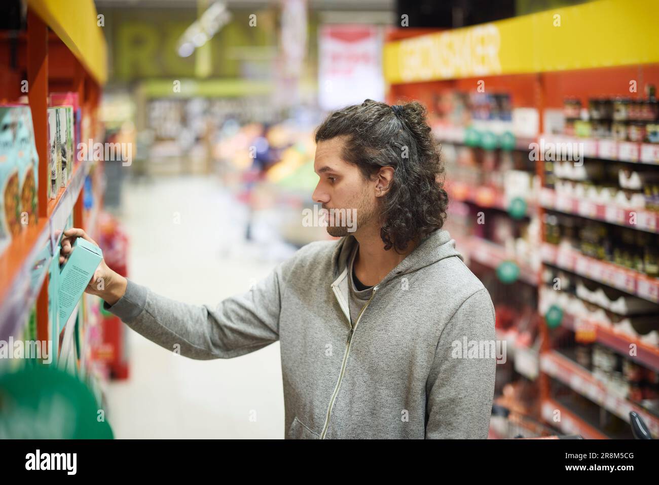 Side view of man doing shopping in supermarket Stock Photo - Alamy