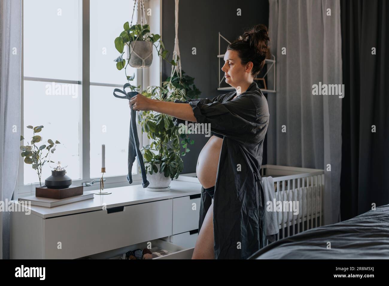 Pregnant woman organizing baby clothes hi-res stock photography and ...