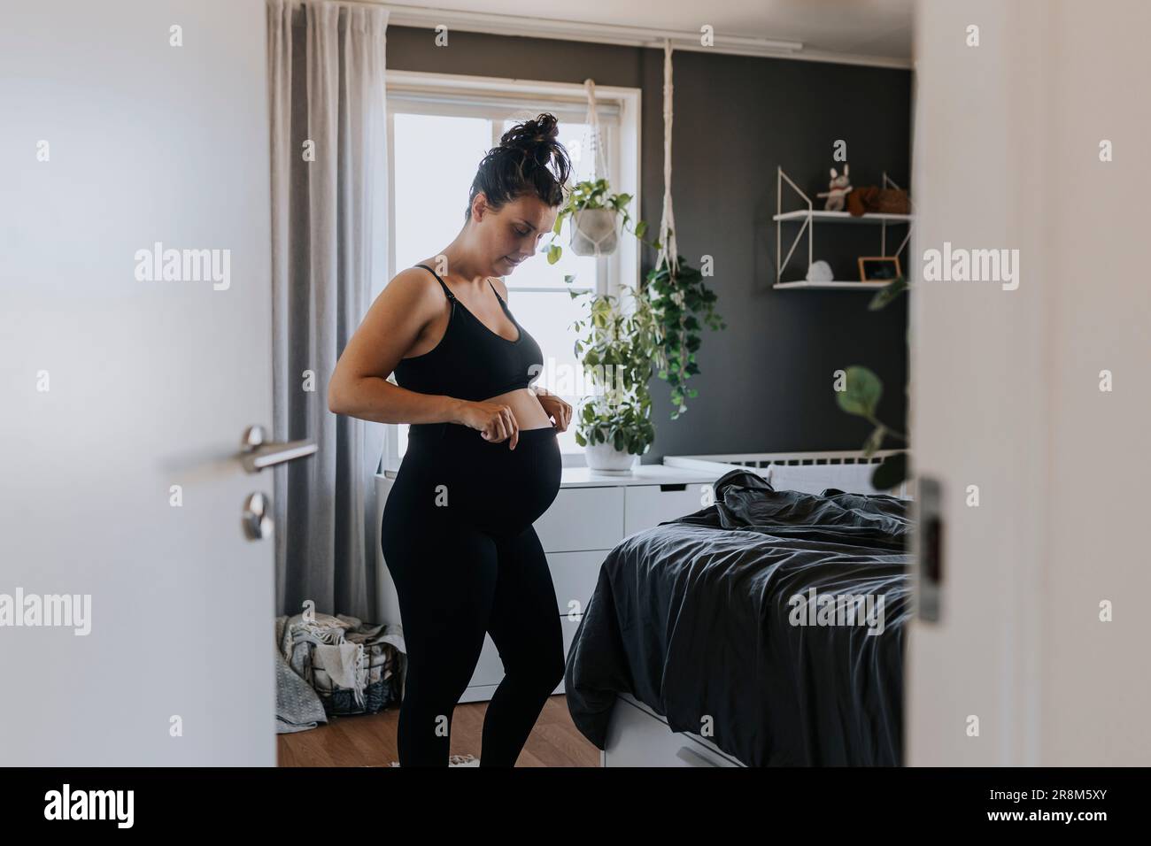 Pregnant woman getting dressed in comfortable clothing Stock Photo - Alamy