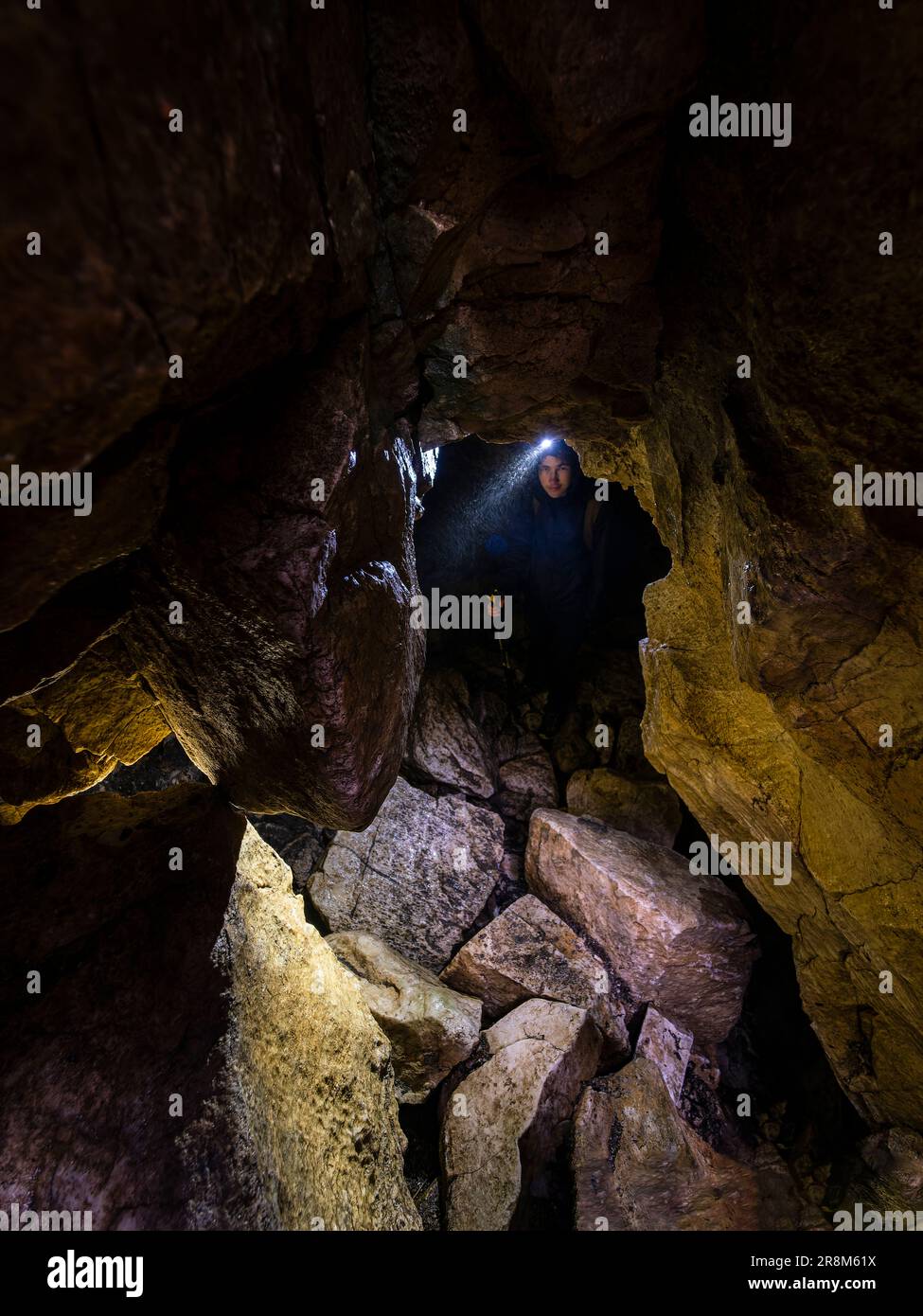 View of man exploring cave Stock Photo - Alamy