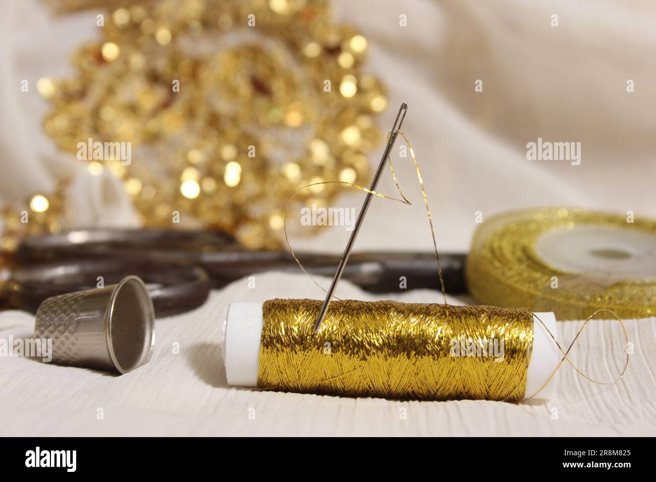 Spool of Gold Metallic Thread and Scissors With Thimble on Off White ...