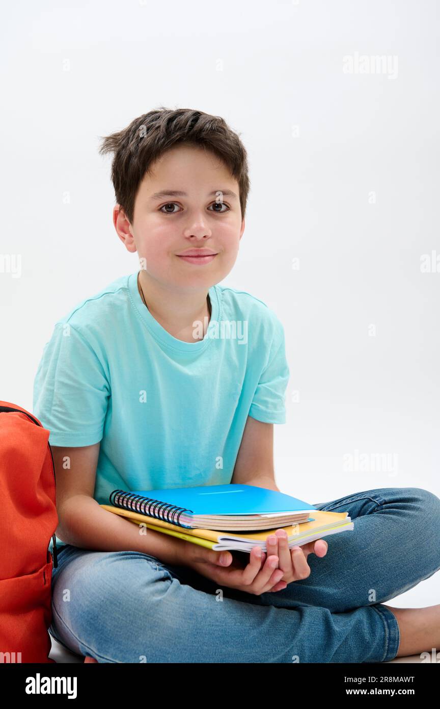 Vertical studio portrait of a handsome happy positive school kid boy ...