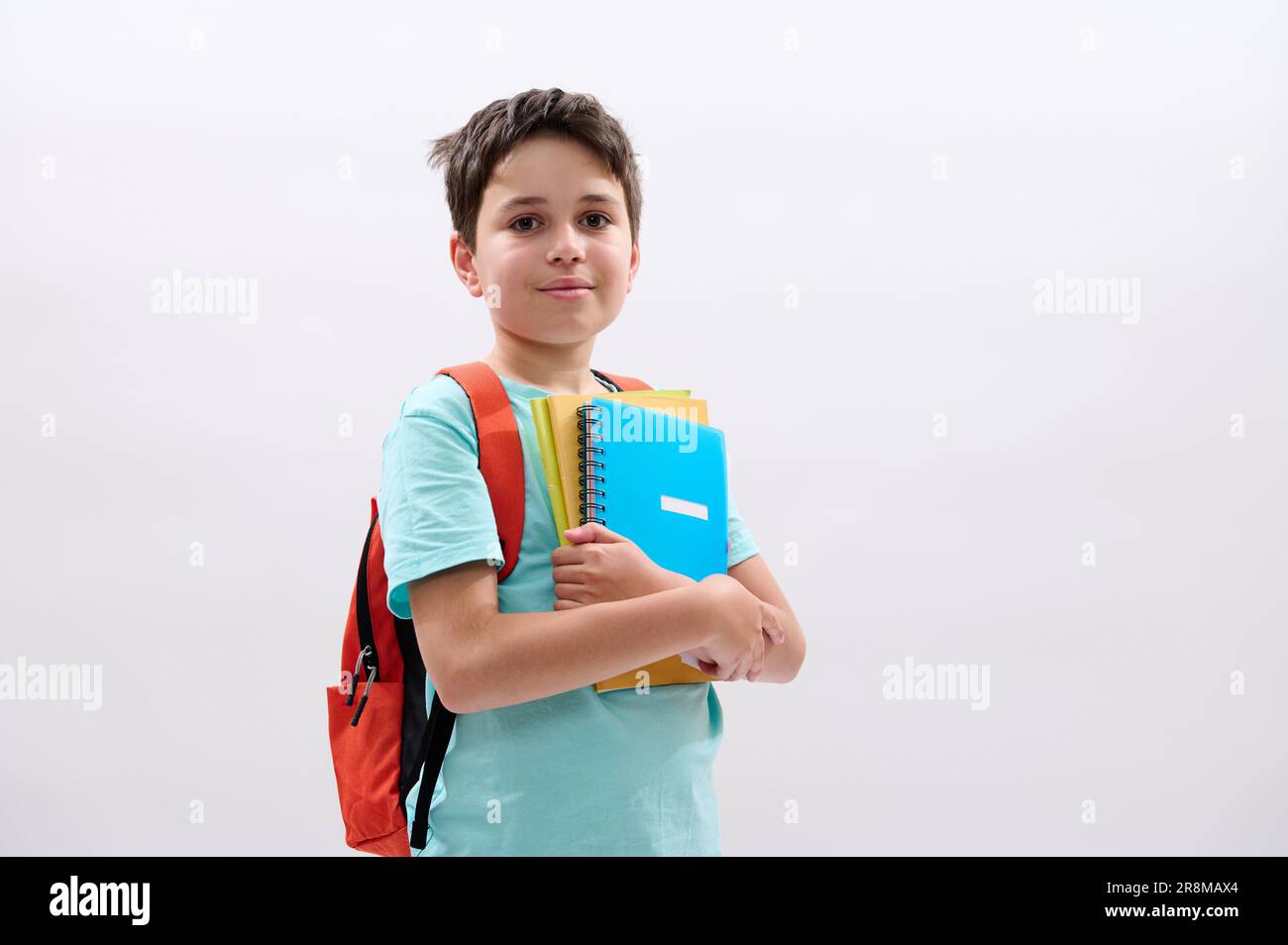 Smart schoolboy carrying orange backpack, colorful textbooks and school ...