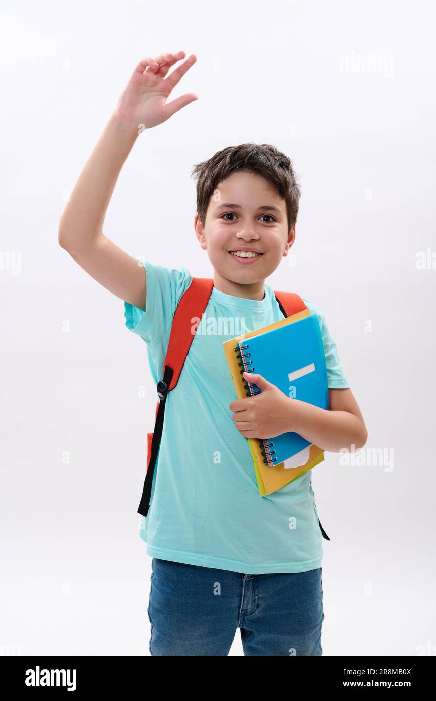 Emotional happy smart schoolboy greeting waving hand, smiling at camera ...