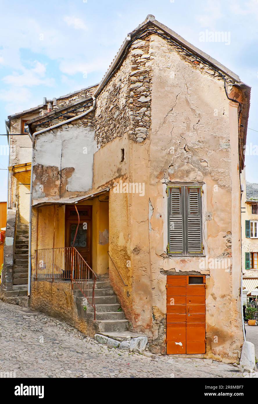 The shabby edifice in old Corte with crumbled plaster and cracks ...