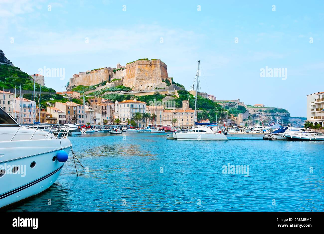 Azure waters of Bonifacio marina with moored yachts, boats, old Jerome ...