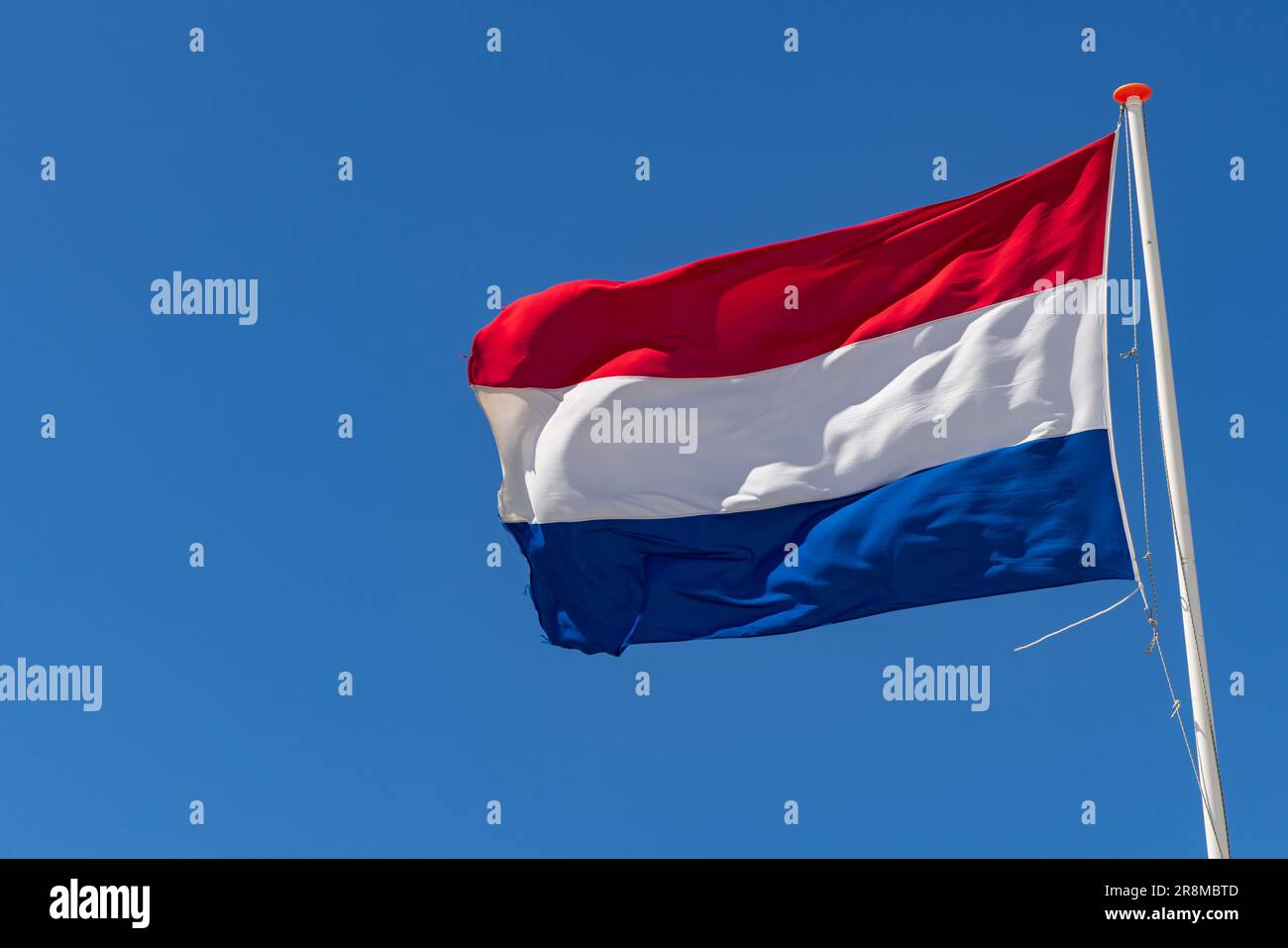 Waving Dutch flag in front of a blue sky in The Netherlands Stock Photo ...