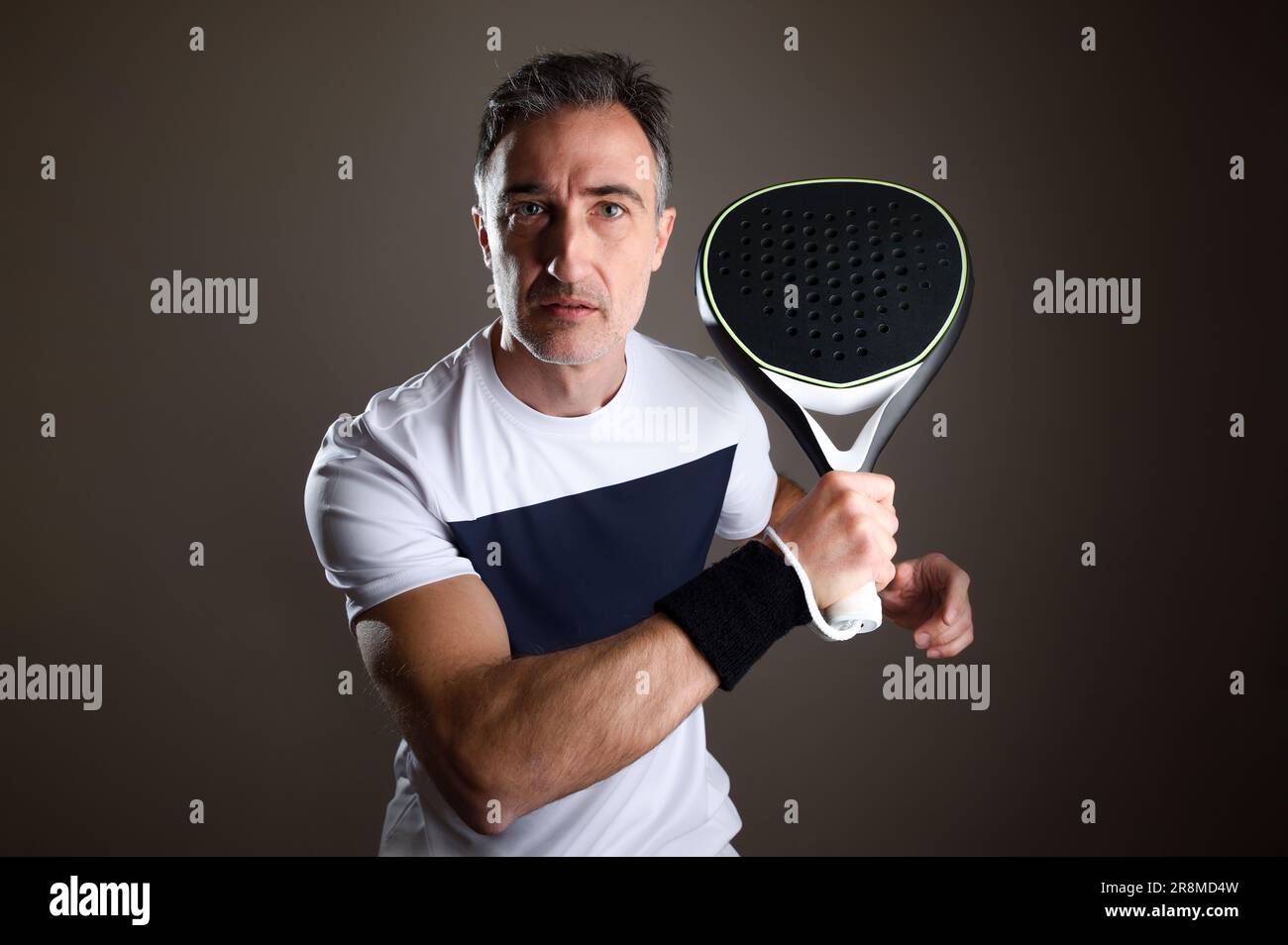 Padel player portrait detail equipped with sportswear and isolated dark ...