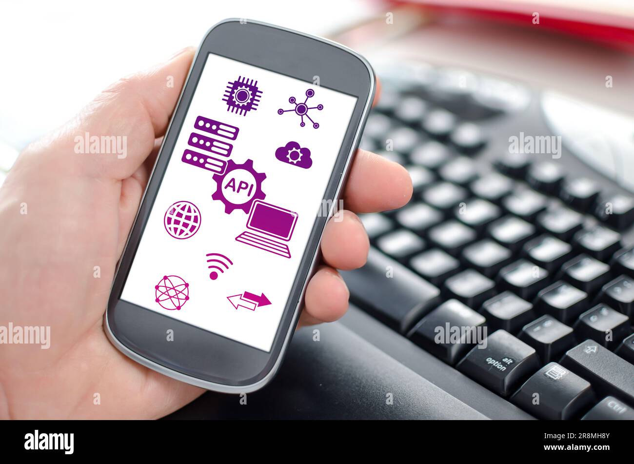 Hand holding a smartphone showing an api concept Stock Photo - Alamy