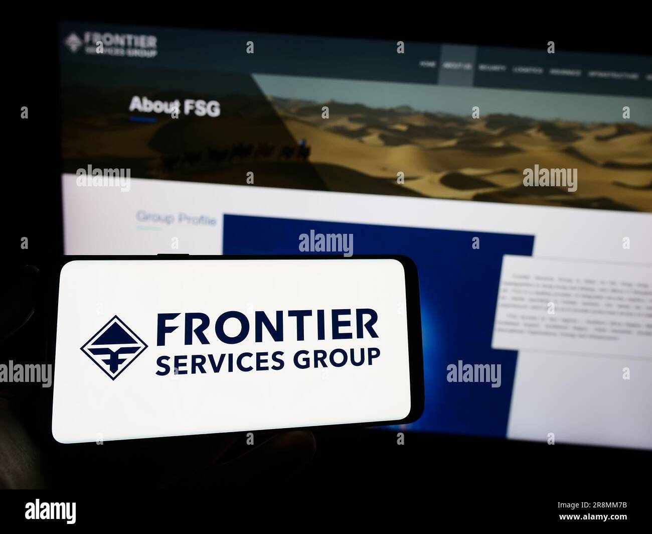 Person holding mobile phone with logo of company Frontier Services ...