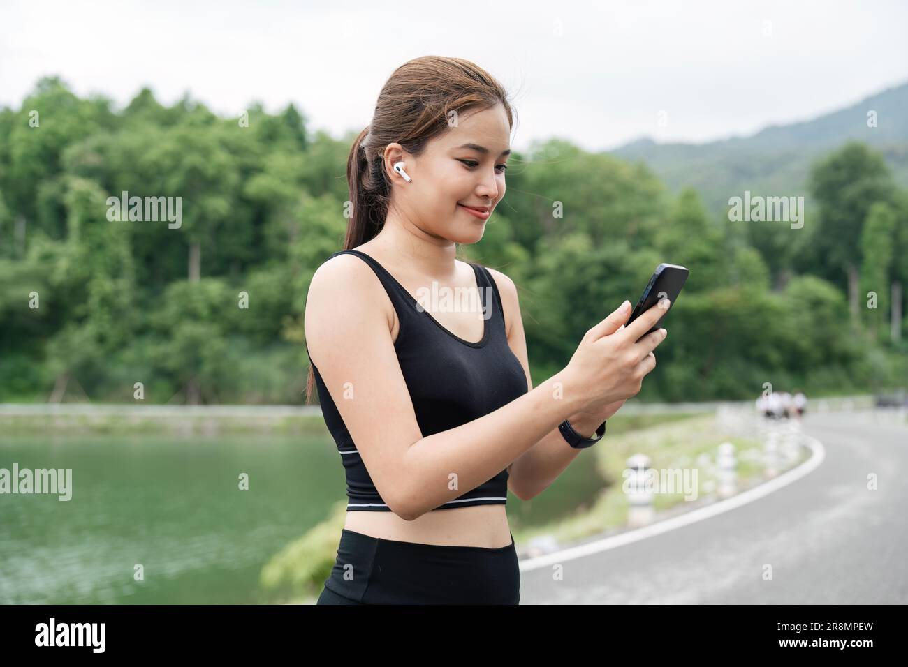 Happy asian girl running and checking her stats, daily goals on smartphone app. Young woman ...