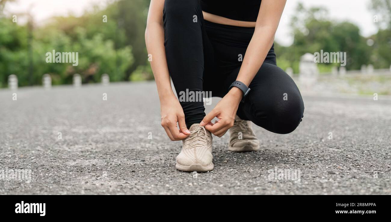 Portrait of a happy active beautiful woman posing fixing shoelace on ...