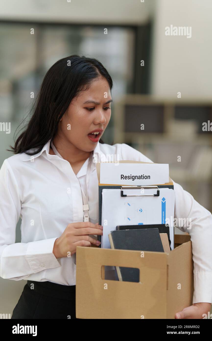 Resignation concept. Fired employee holding box of belongings in an ...