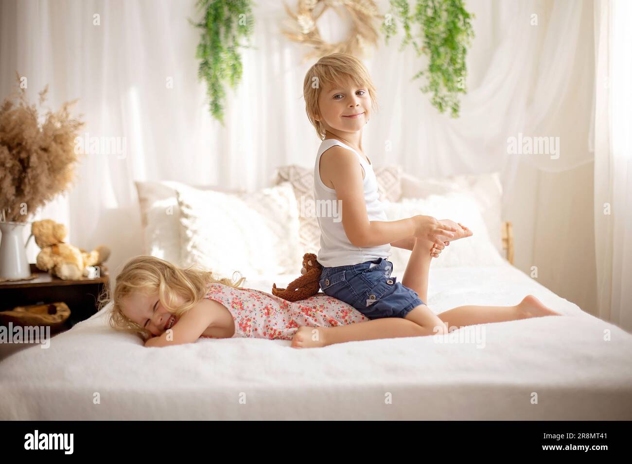 Cute sweet toddler children, tickling feet on the bed, laughing and ...