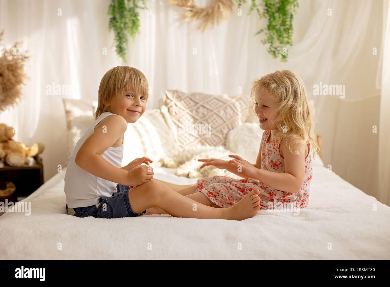 Cute sweet toddler children, tickling feet on the bed, laughing and ...