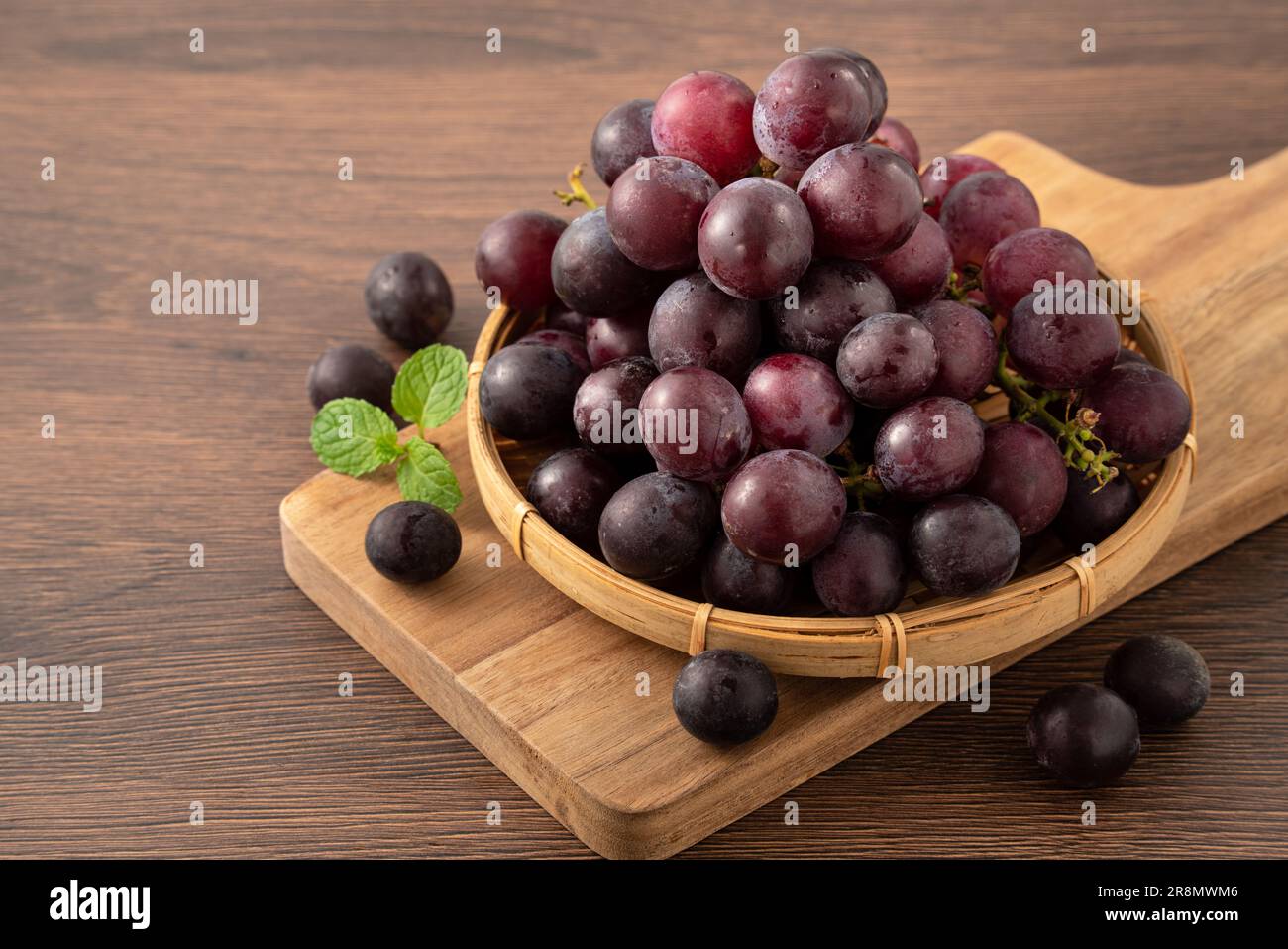 Delicious bunch of purple grapes fruit on a tray over wooden table ...