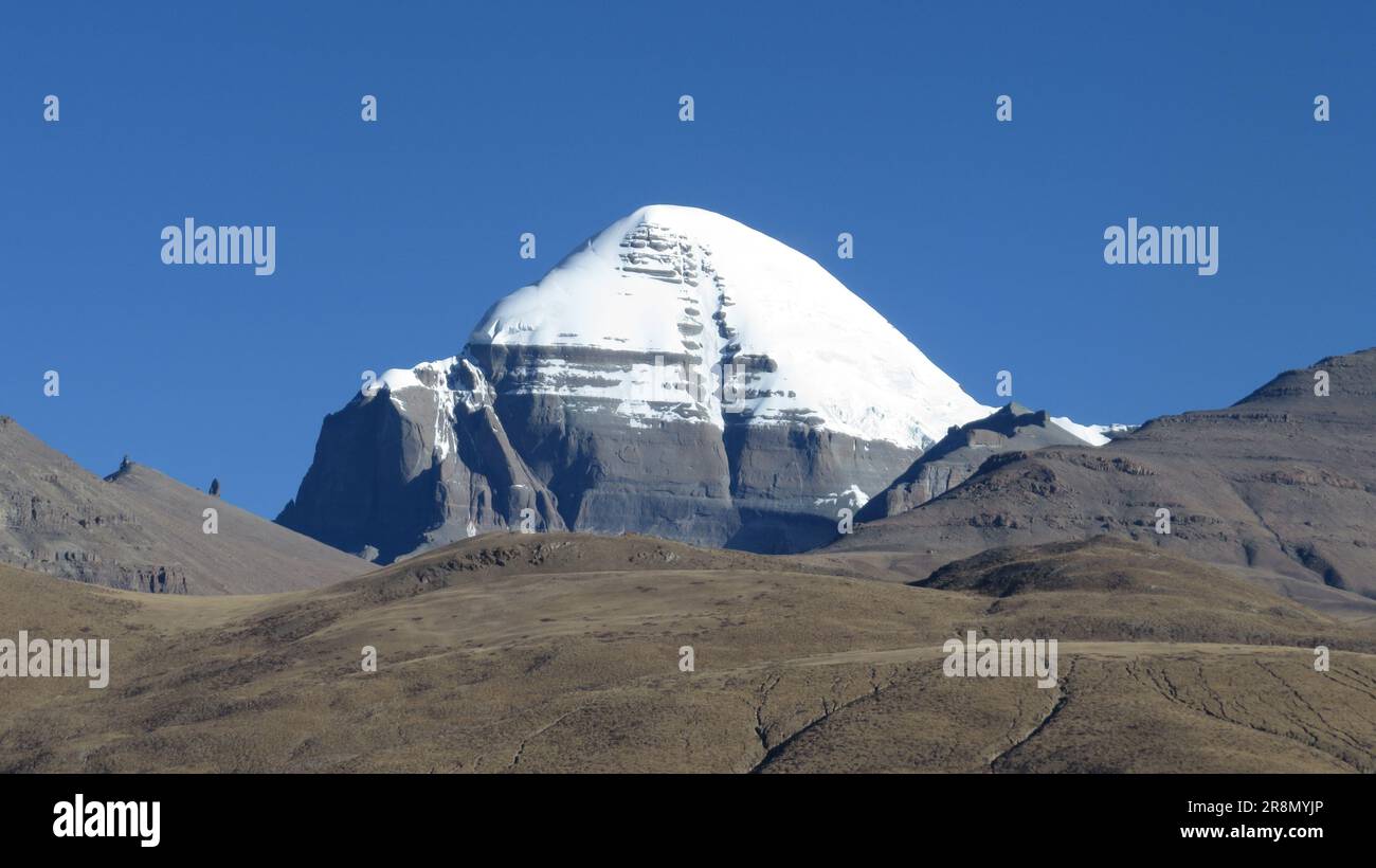 Majestic snow-capped Mount Kailash rises under a clear blue sky, a ...