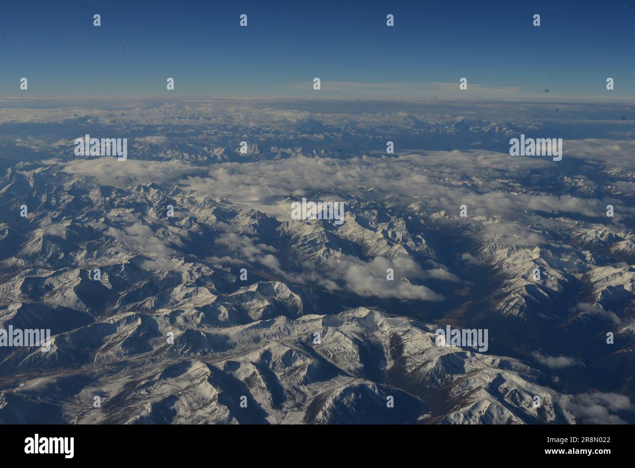 Aerial view of a vast snow-covered mountain range with rugged peaks ...