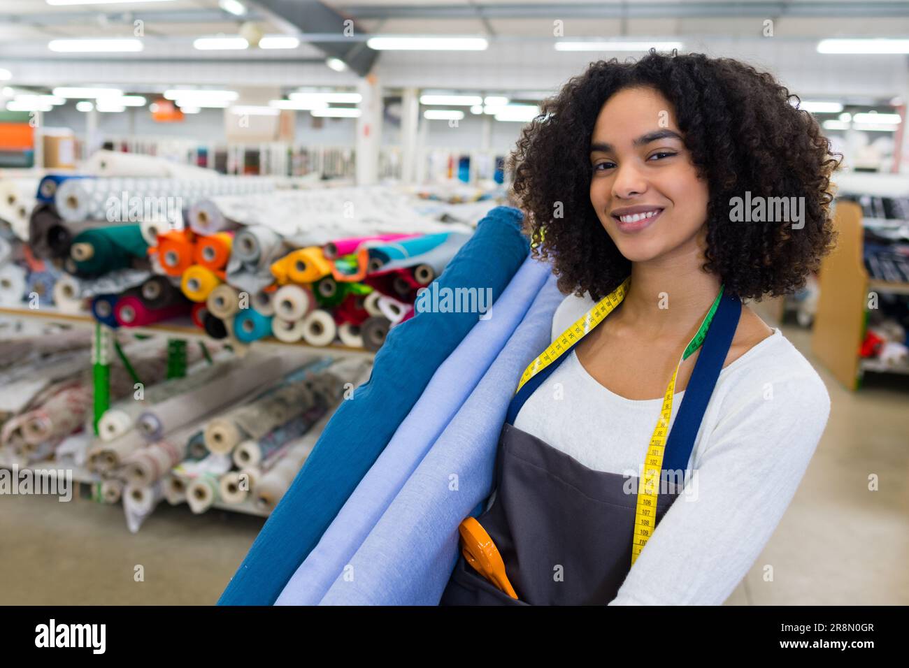 female tailor carrying rolls of textile fabric Stock Photo - Alamy