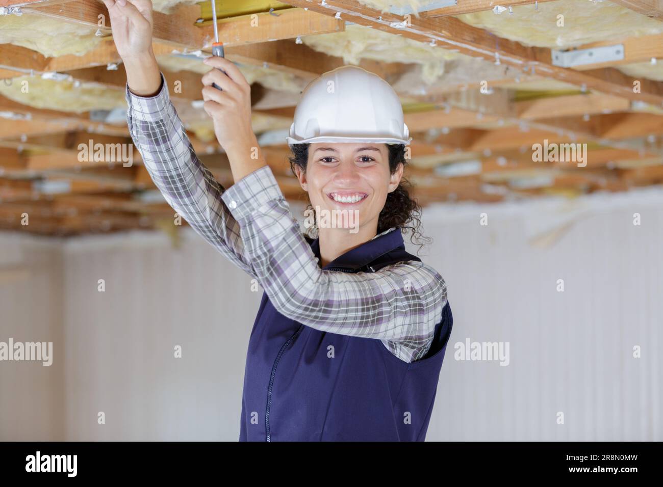 a female worker is installing suspended ceiling Stock Photo - Alamy