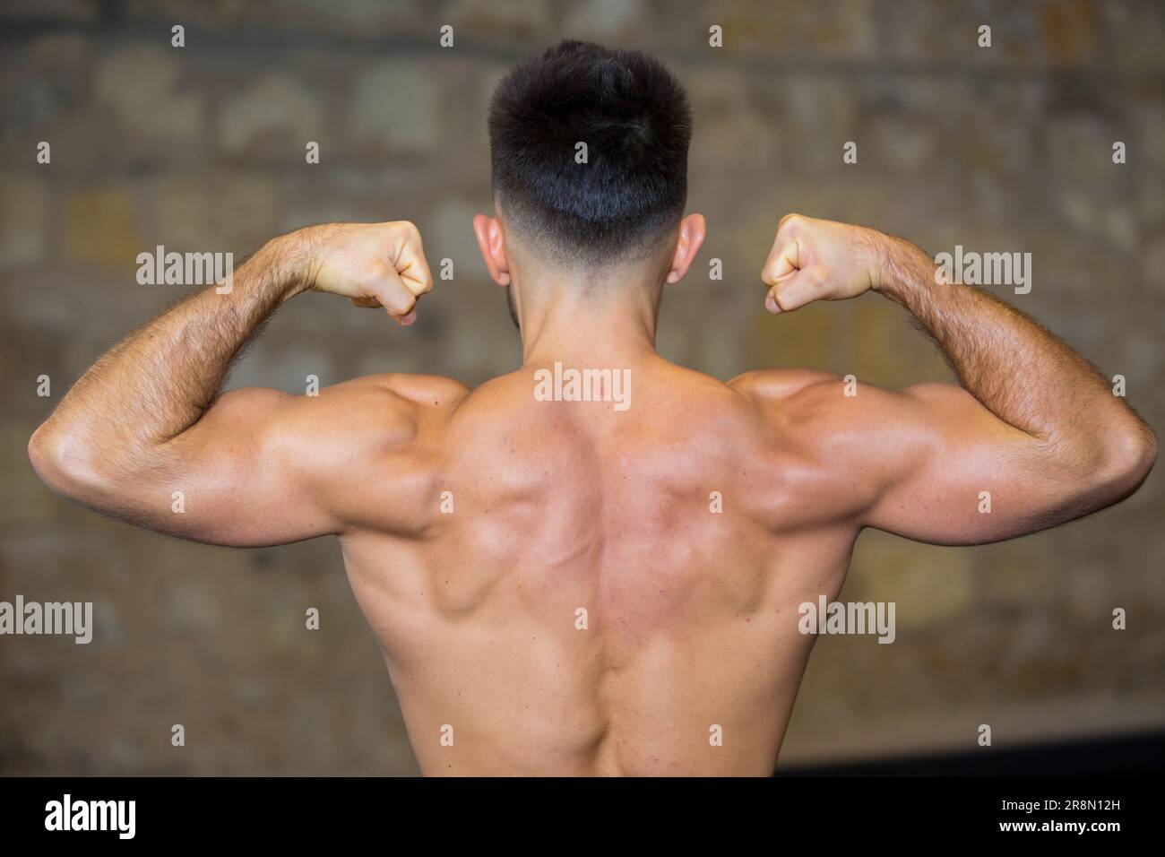 man flexing his back and arm muscles Stock Photo - Alamy