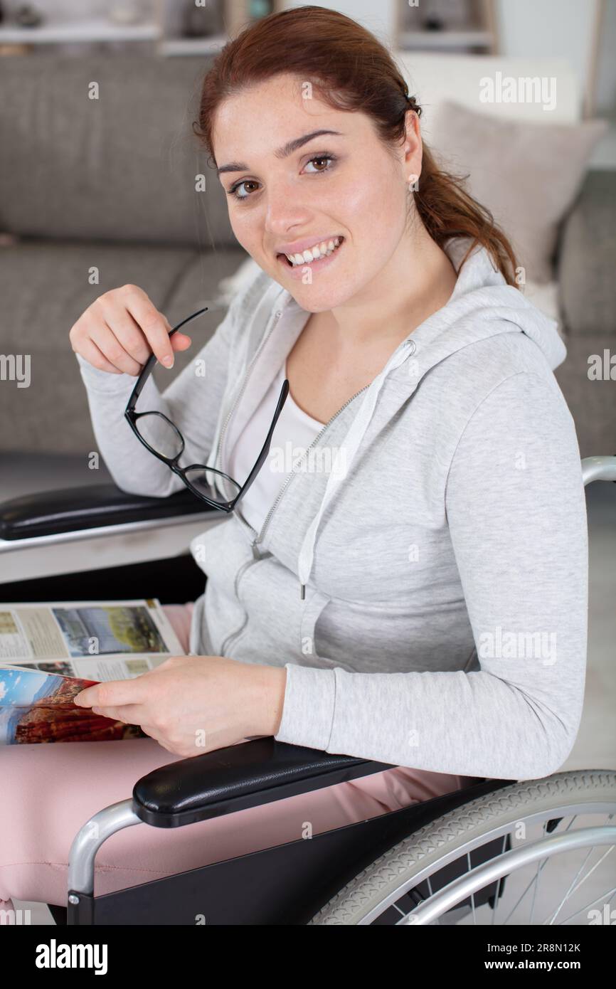 inspired disabled woman sitting in a wheelchair and holding magazine ...