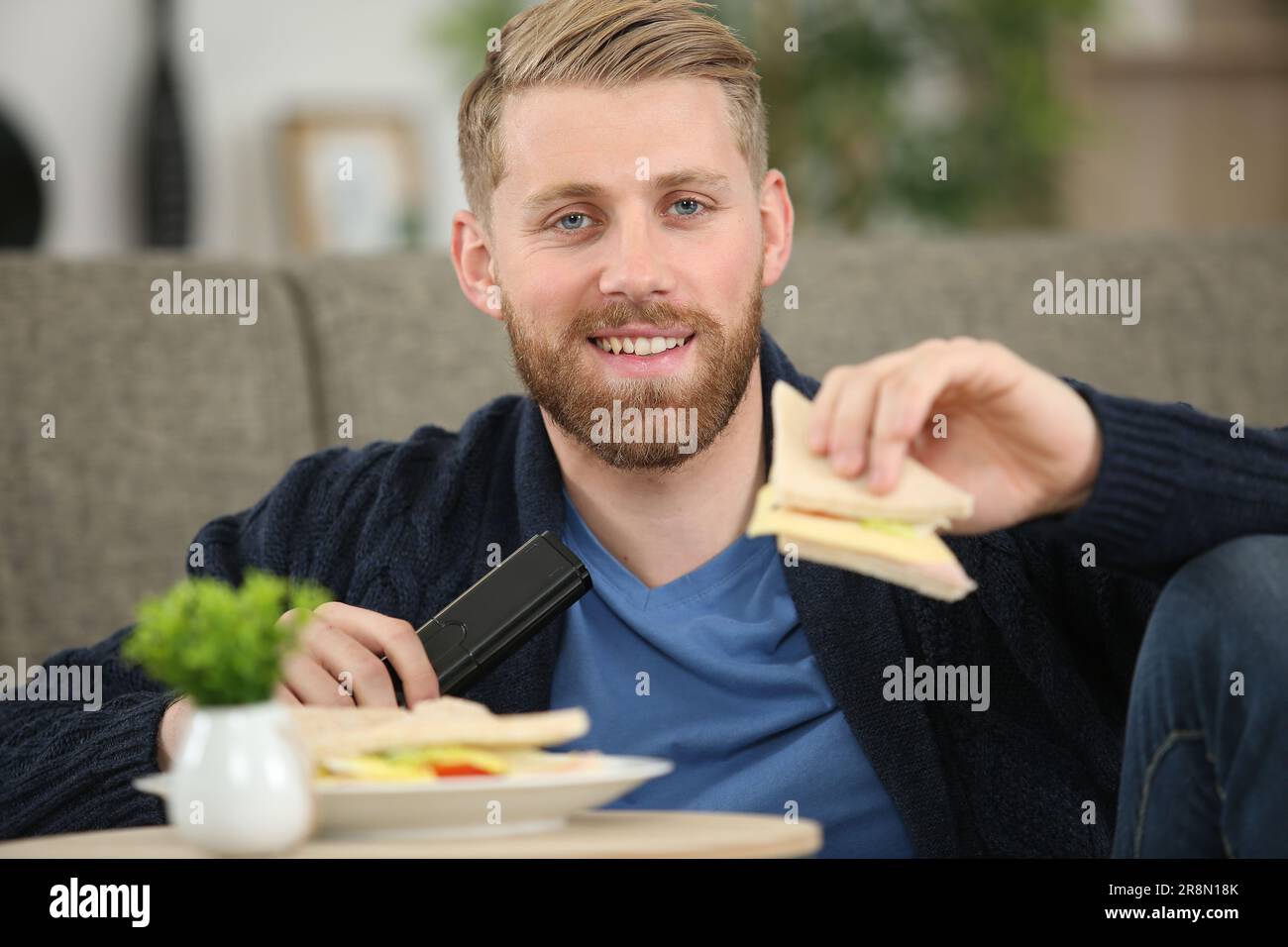 hungry young man eating sandwich at home Stock Photo - Alamy