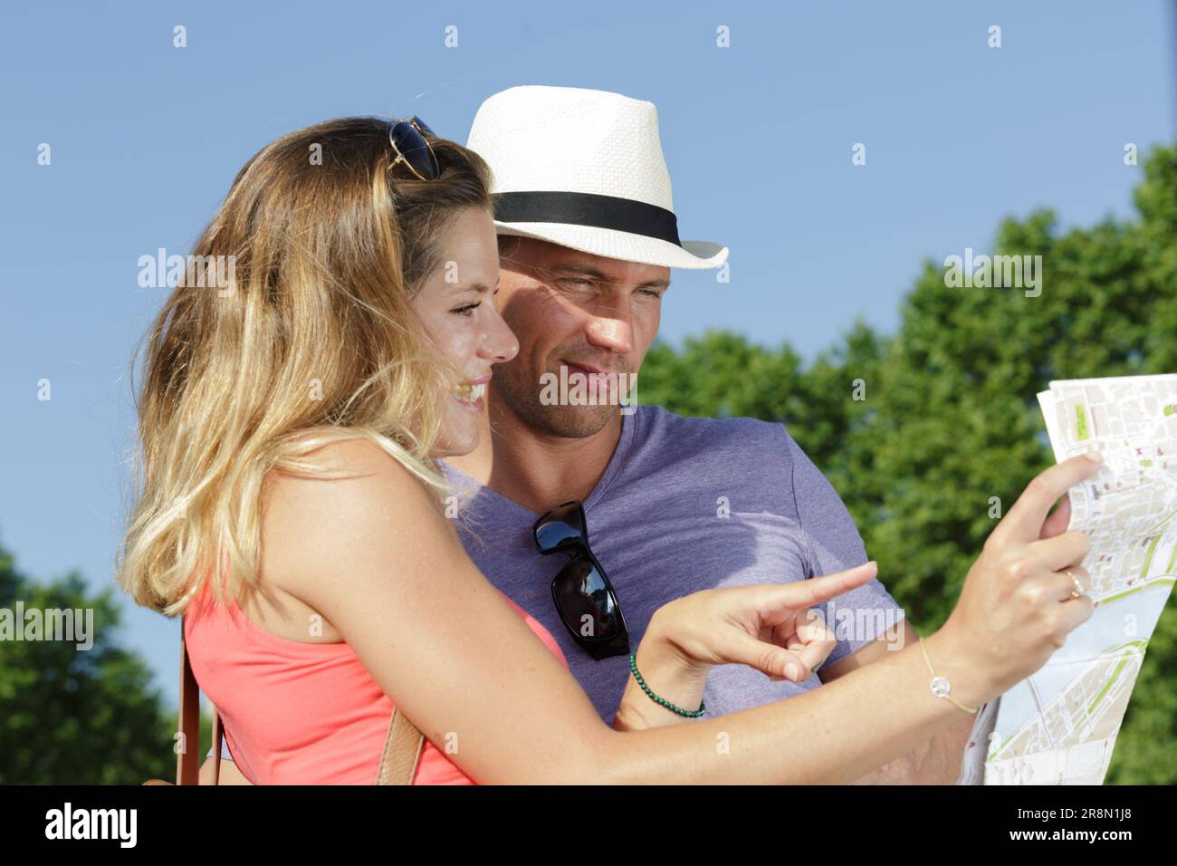 couple holding tourist map in a sunny destination Stock Photo - Alamy