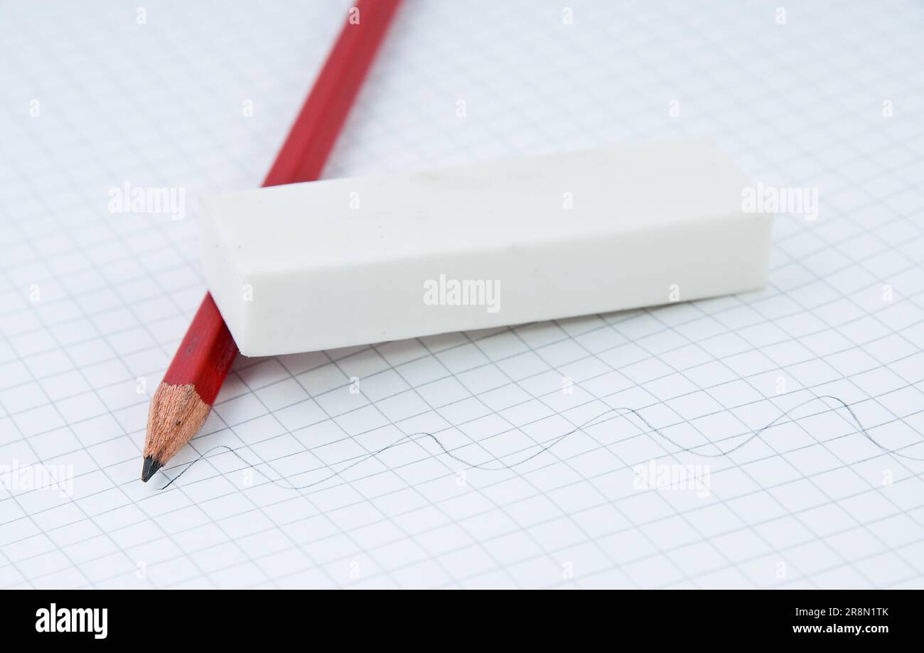 Pencil and eraser on a squared white sheet of paper Stock Photo - Alamy