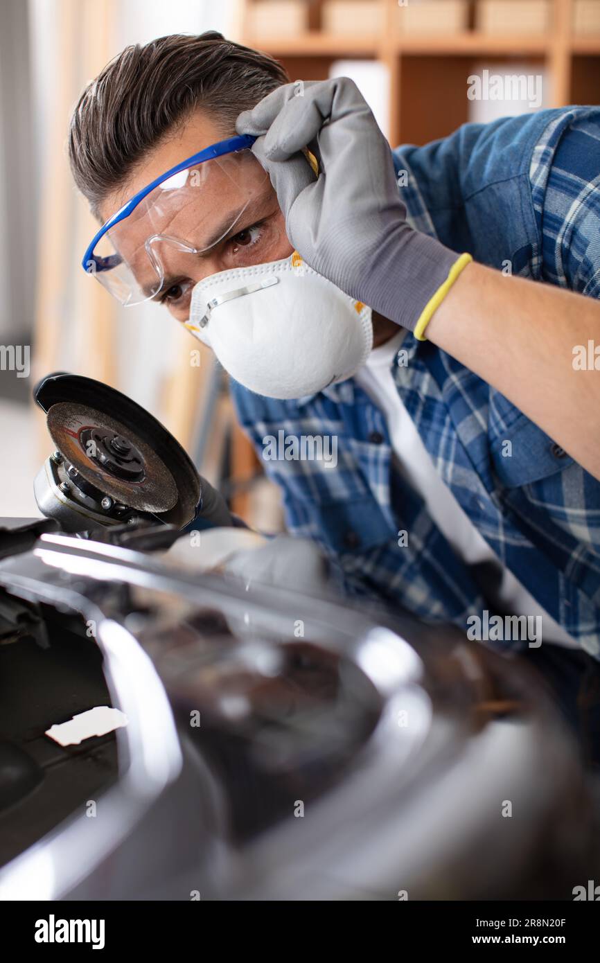 mechanic wearing dust mask using an angle grinder Stock Photo - Alamy