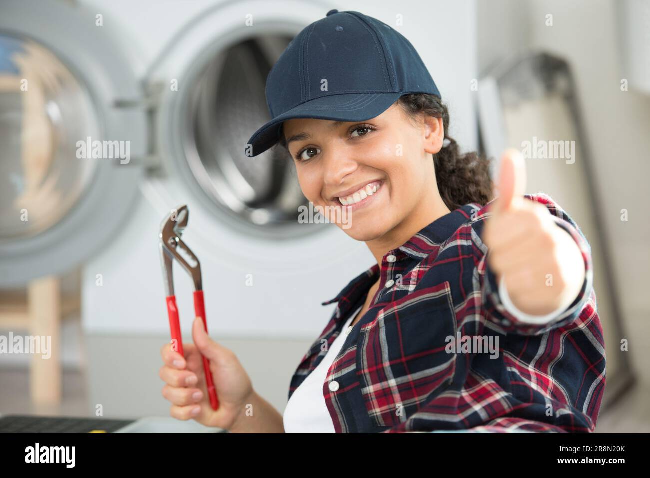 female technician fixing washing machine Stock Photo - Alamy