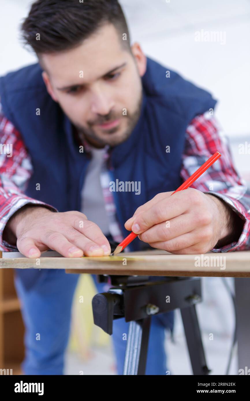 carpenter drawing a line where to cut Stock Photo - Alamy