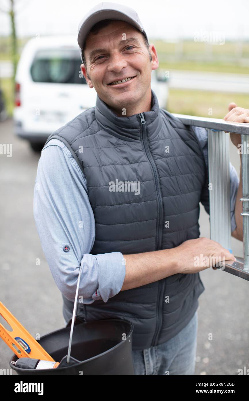 maintenance worker man carrying aluminium step ladder Stock Photo - Alamy
