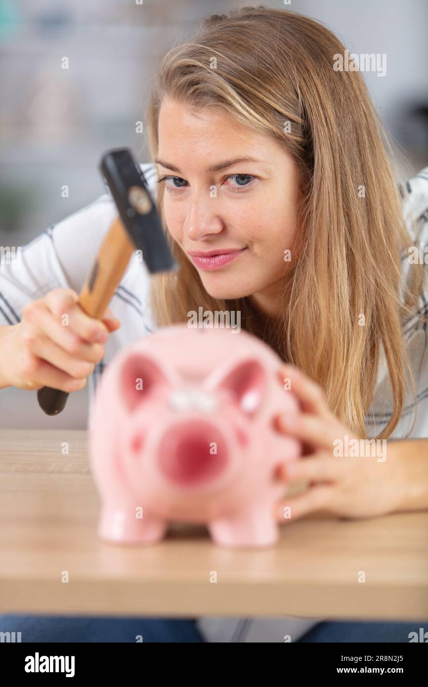 Female breaking piggy bank hi-res stock photography and images - Alamy
