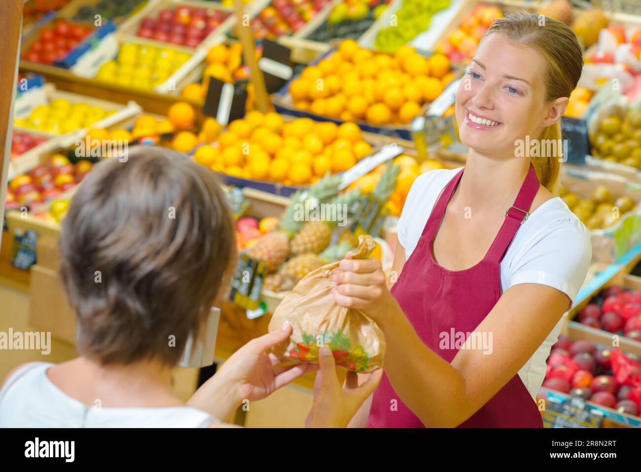 girl giving goods to customer Stock Photo - Alamy