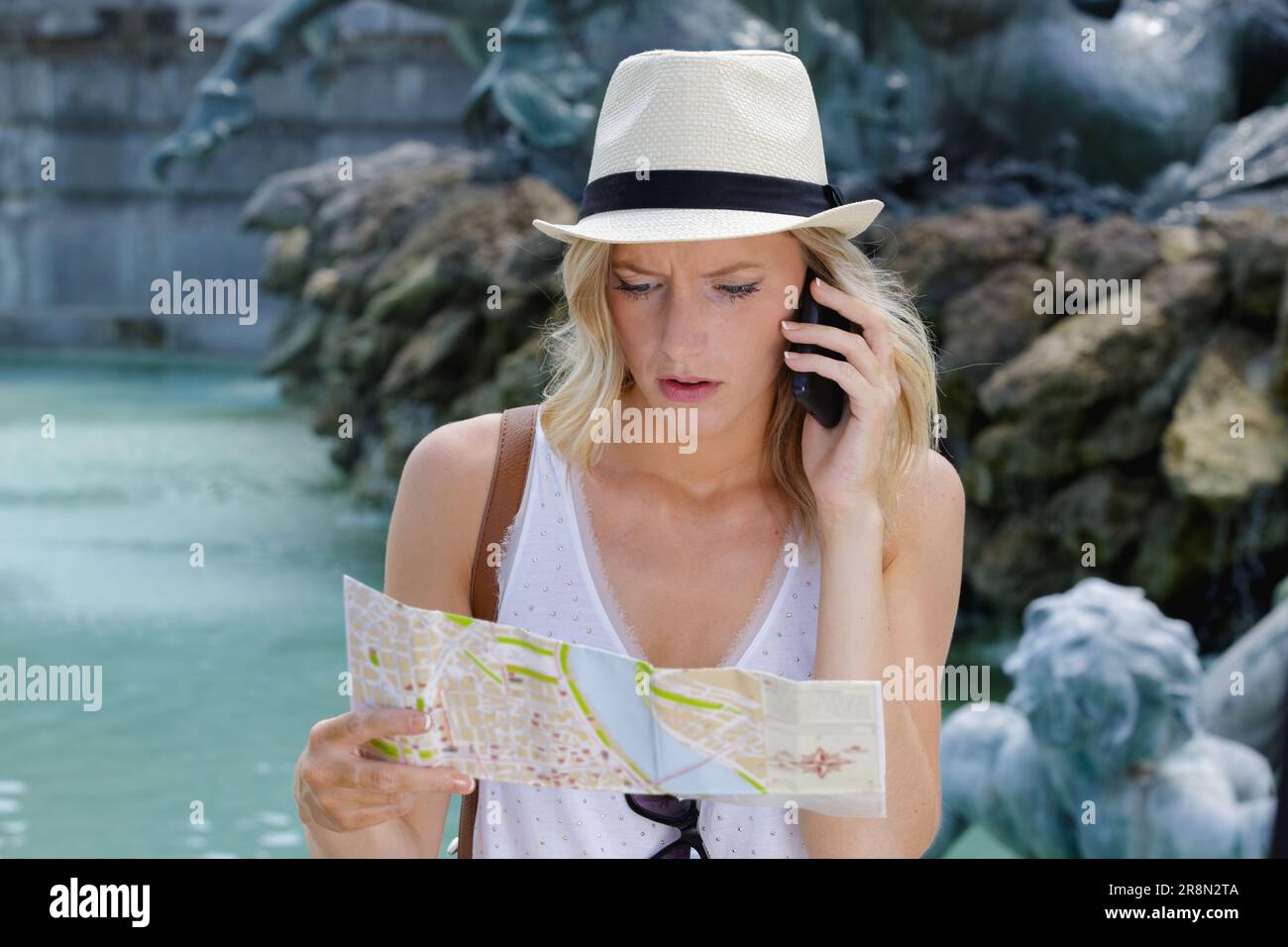 female tourist talking on cellphone while reading the map Stock Photo ...