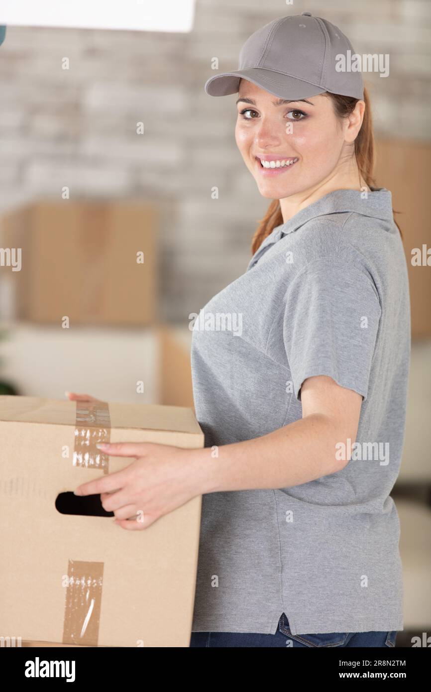 delivery smiling woman in uniform and cap working as courier Stock ...