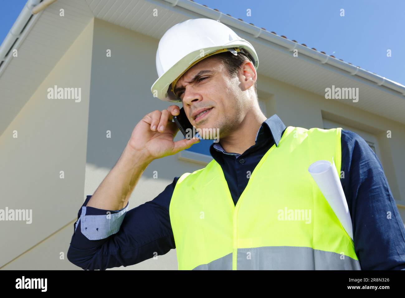 engineer wearing safety helmet and talking smartphone outdoors Stock ...