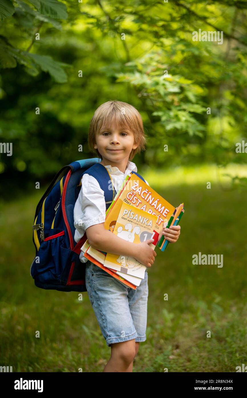 Cute preschool child, wearing school backpack, holding notebook and ...