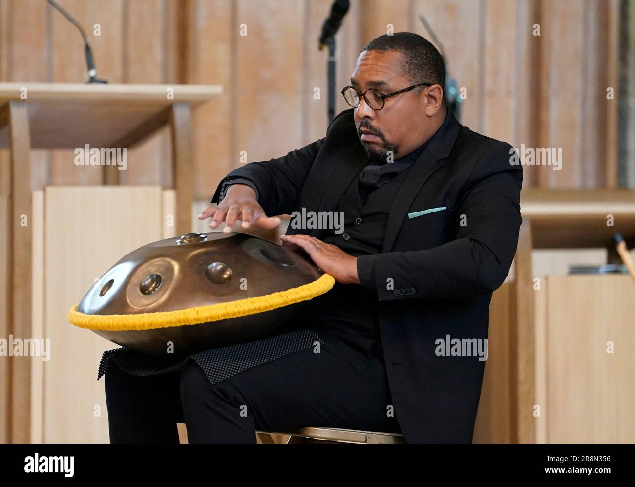 The Reverend Jonathan Coore plays a lament during a service, attended ...
