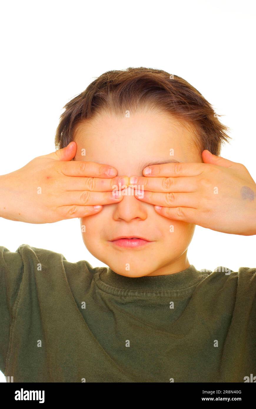 Boy puts his hands in front of his eyes, keeps them closed, keeps them ...