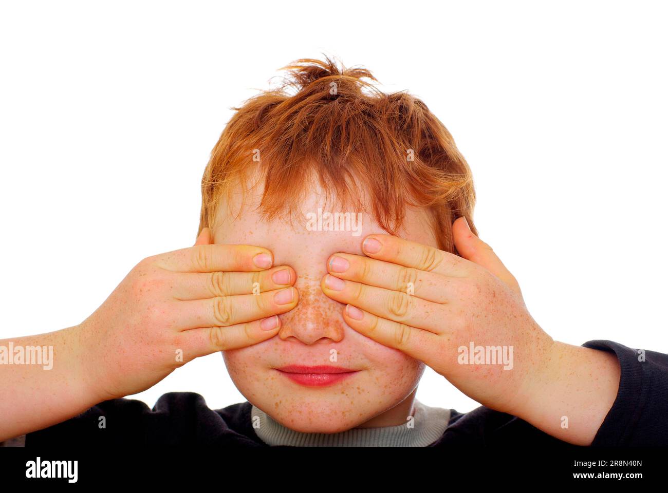 Boy puts his hands in front of his eyes, keeps them closed, keeps them ...