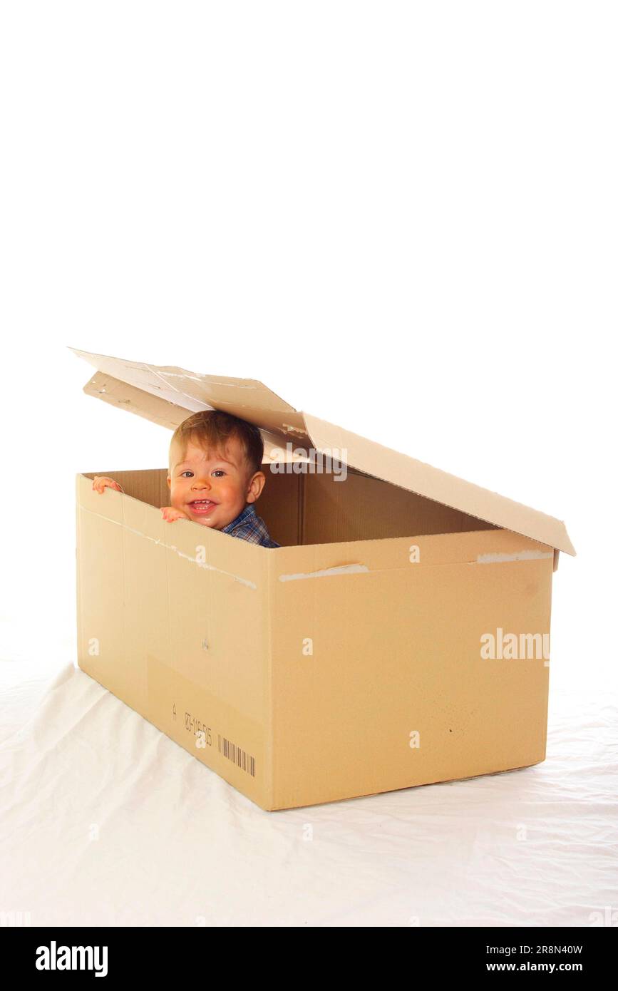 Boy in a box, hiding, looking out, hiding, freelance Stock Photo - Alamy