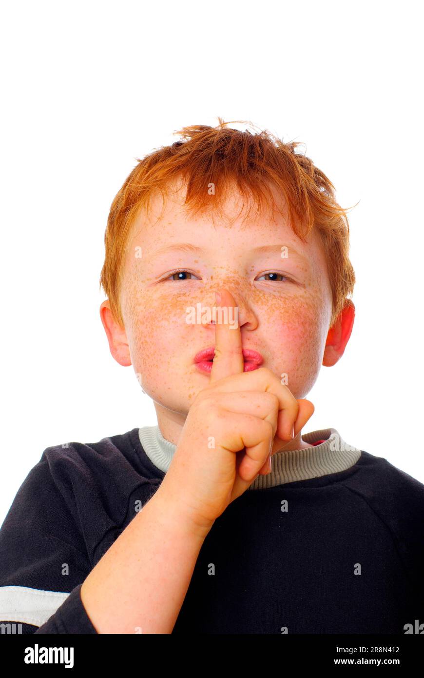 Boy holds index finger in front of mouth, Shh, be quiet, silence, don't ...