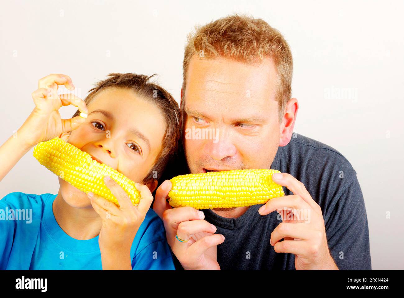 Father and son eating an ear of corn, corn Stock Photo - Alamy
