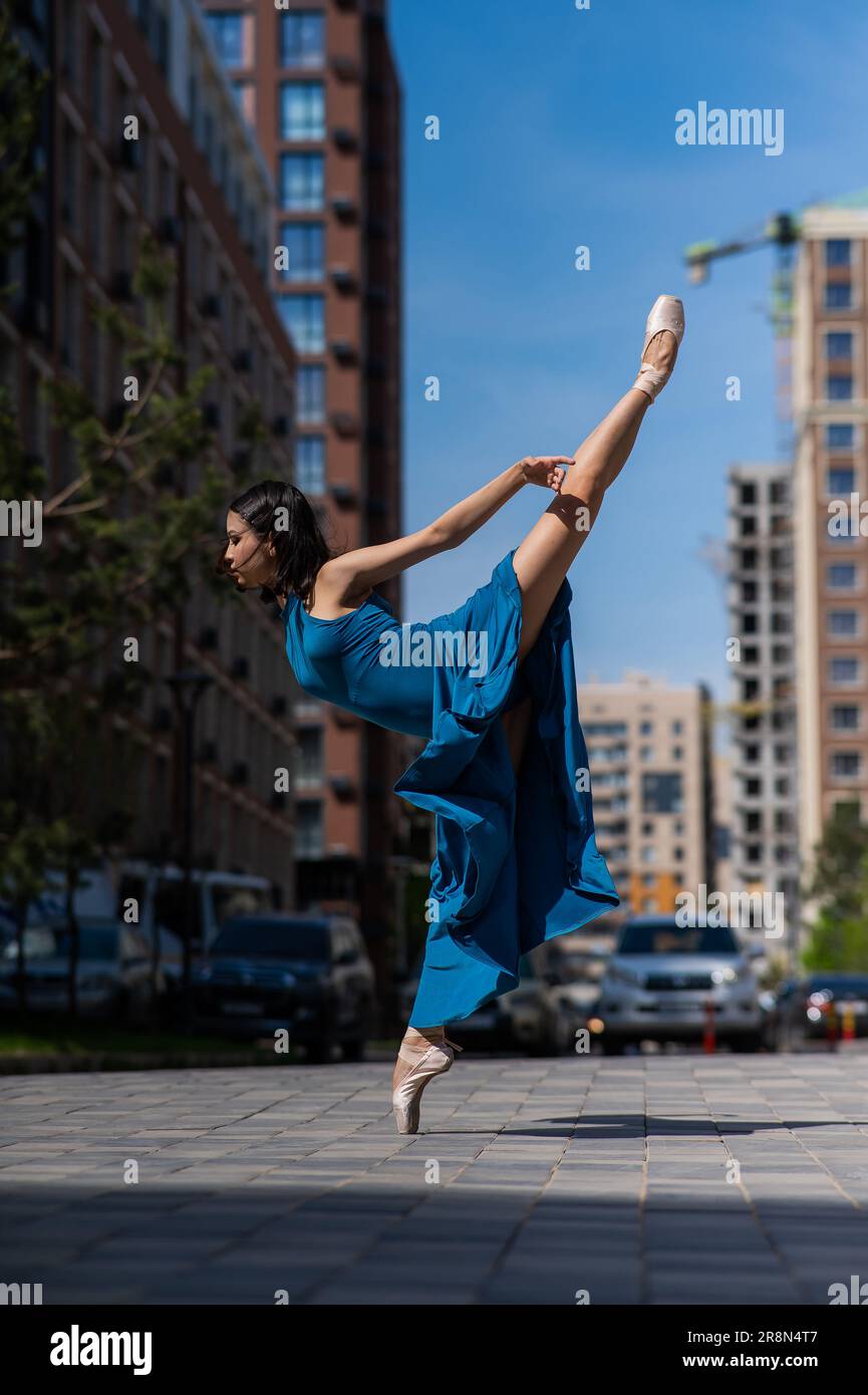 Beautiful Asian ballerina dancing outdoors. Urban landscape Stock Photo ...