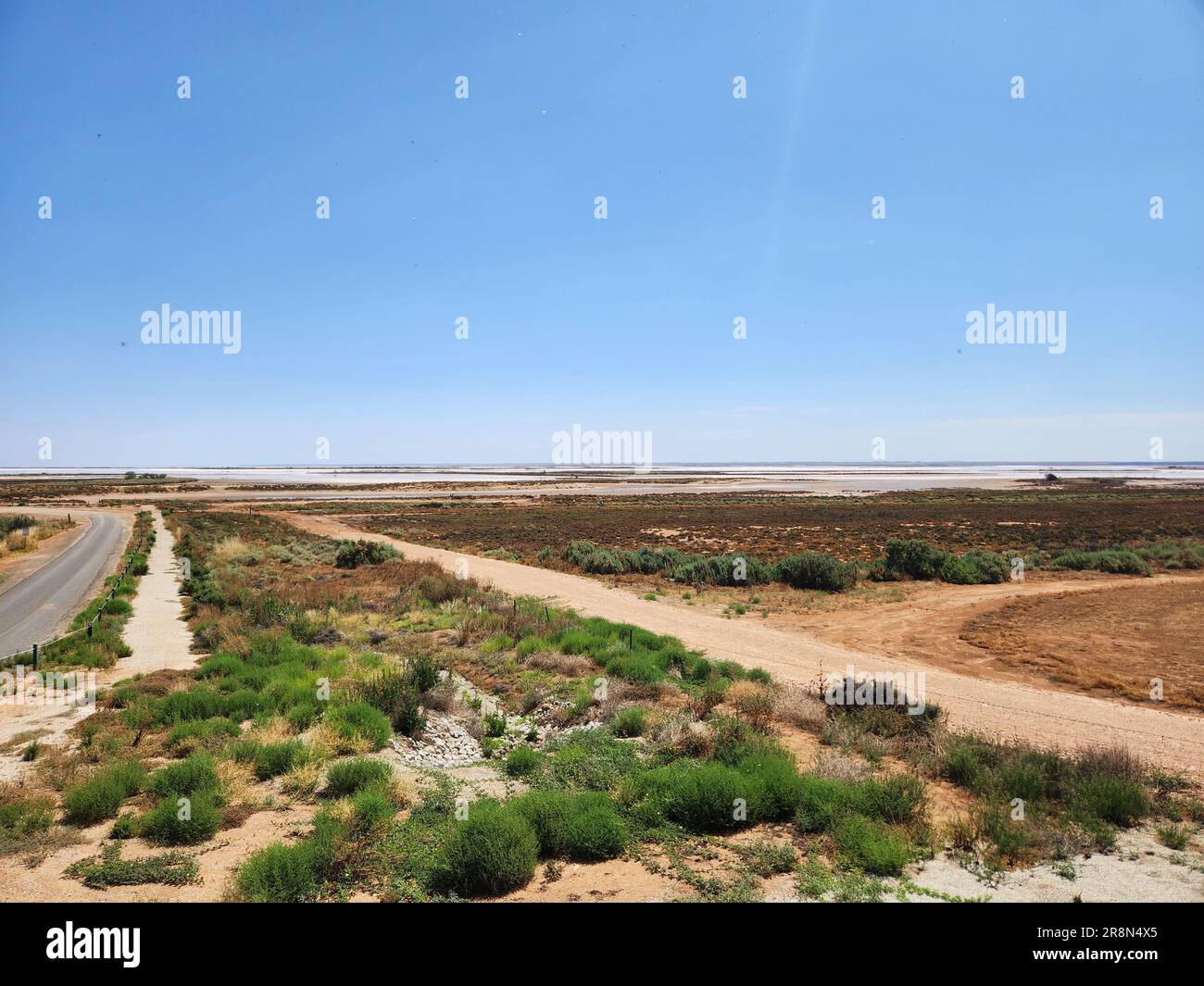 A scenic view of a winding road in a vast desert landscape leading to a ...