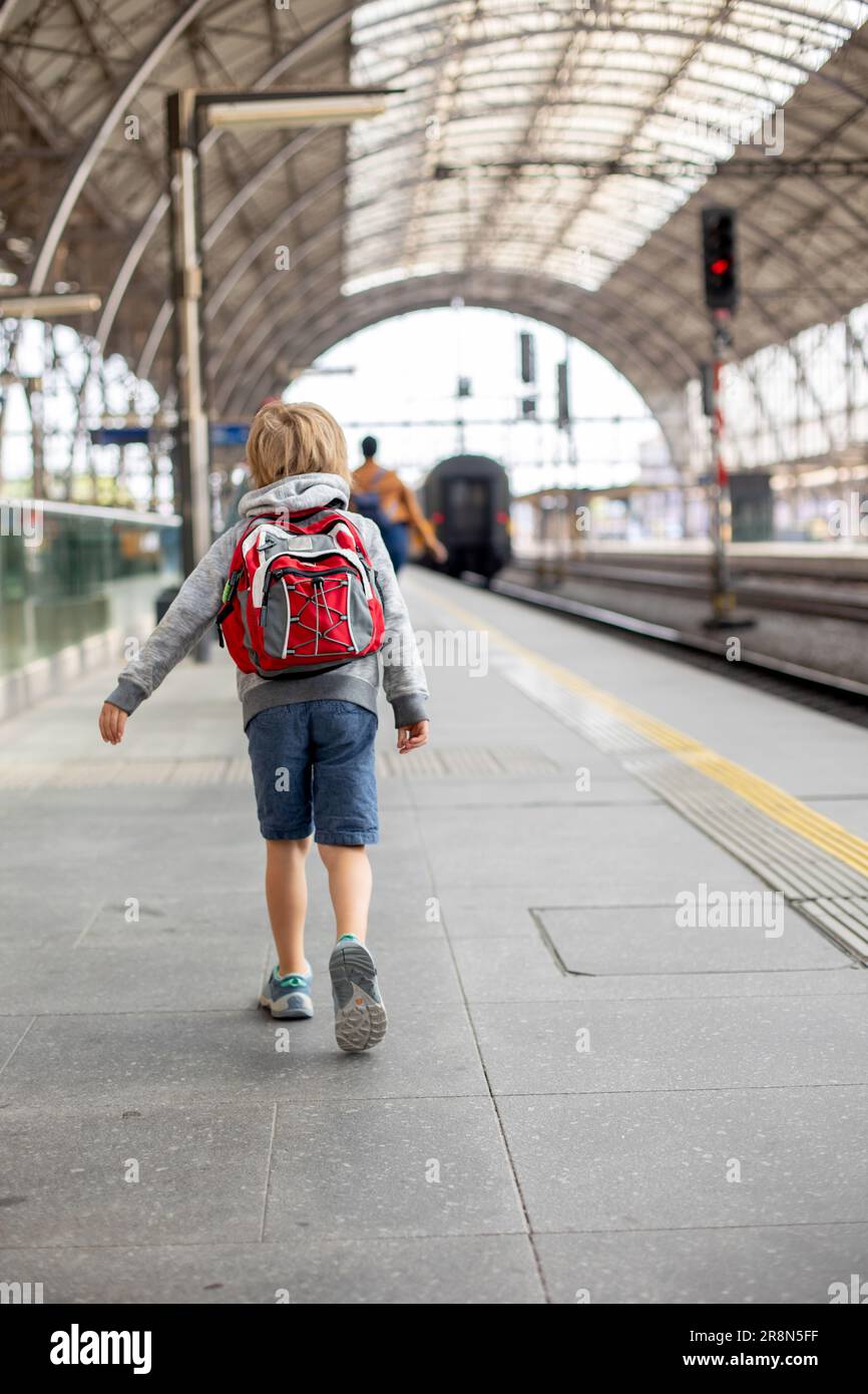 Cute preschool child with backpack, running for the train on a ...