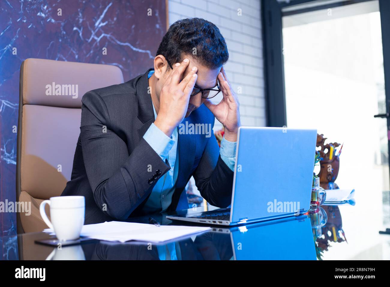 Stressed indian businessman working on laptop computer in office ...
