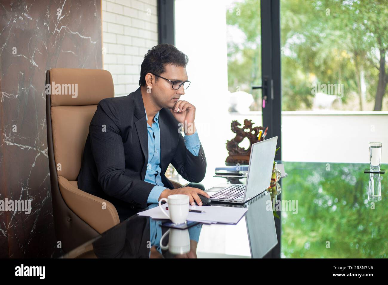 Successful handsome indian businessman working on laptop computer in ...